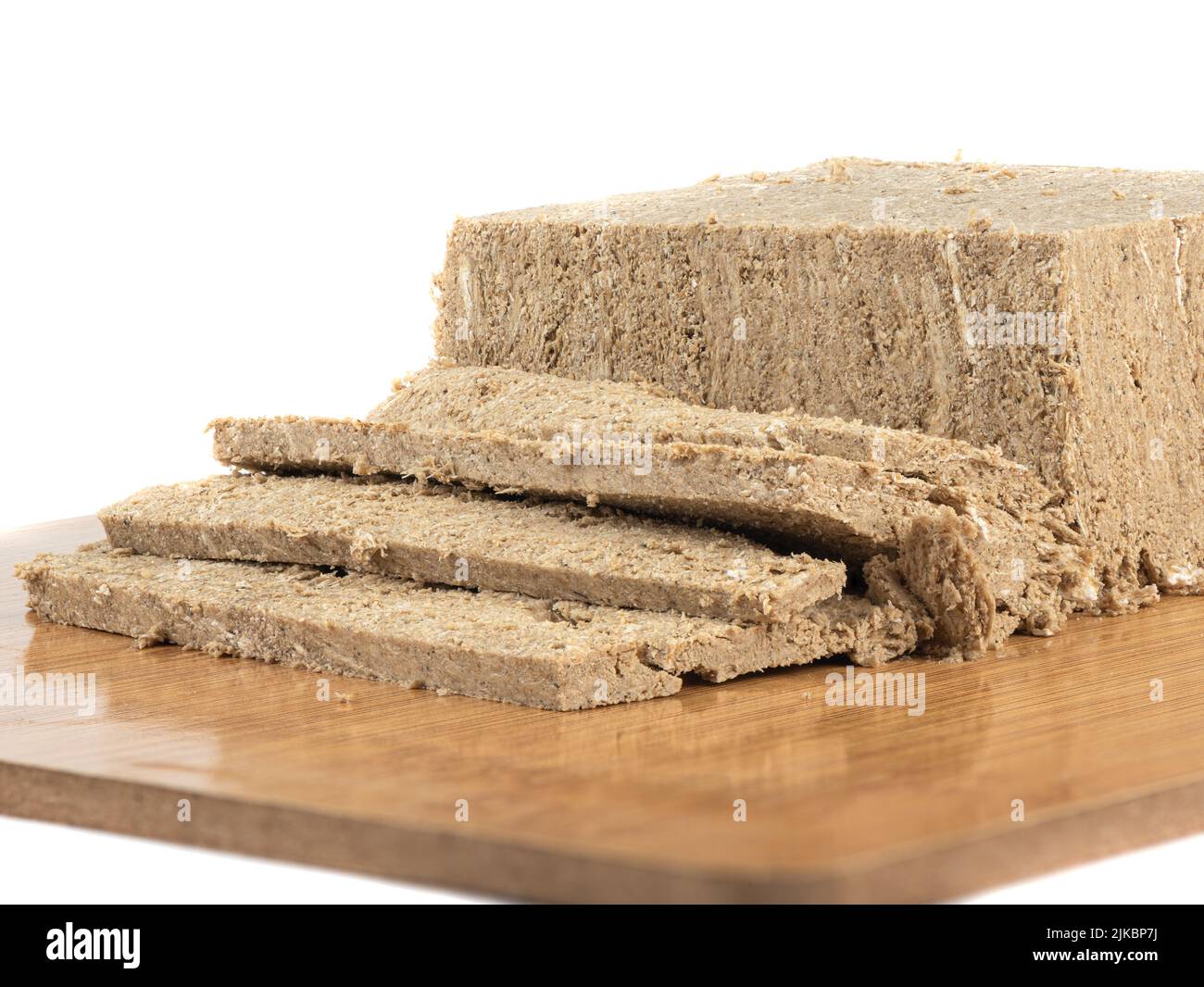 Sliced sunflower halva on a bamboo cutting board over white background ...