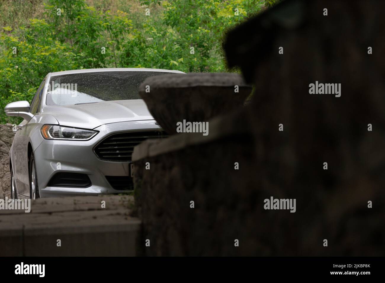 Armenia - July 22, 2022: Half visible Ford Fusion behind a stone ...