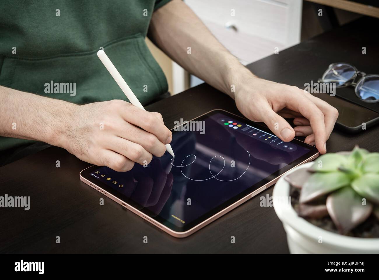 KIEV, UKRAINE - DECEMBER 21, 2021:Man with Apple Pencil using iPad Pro ...