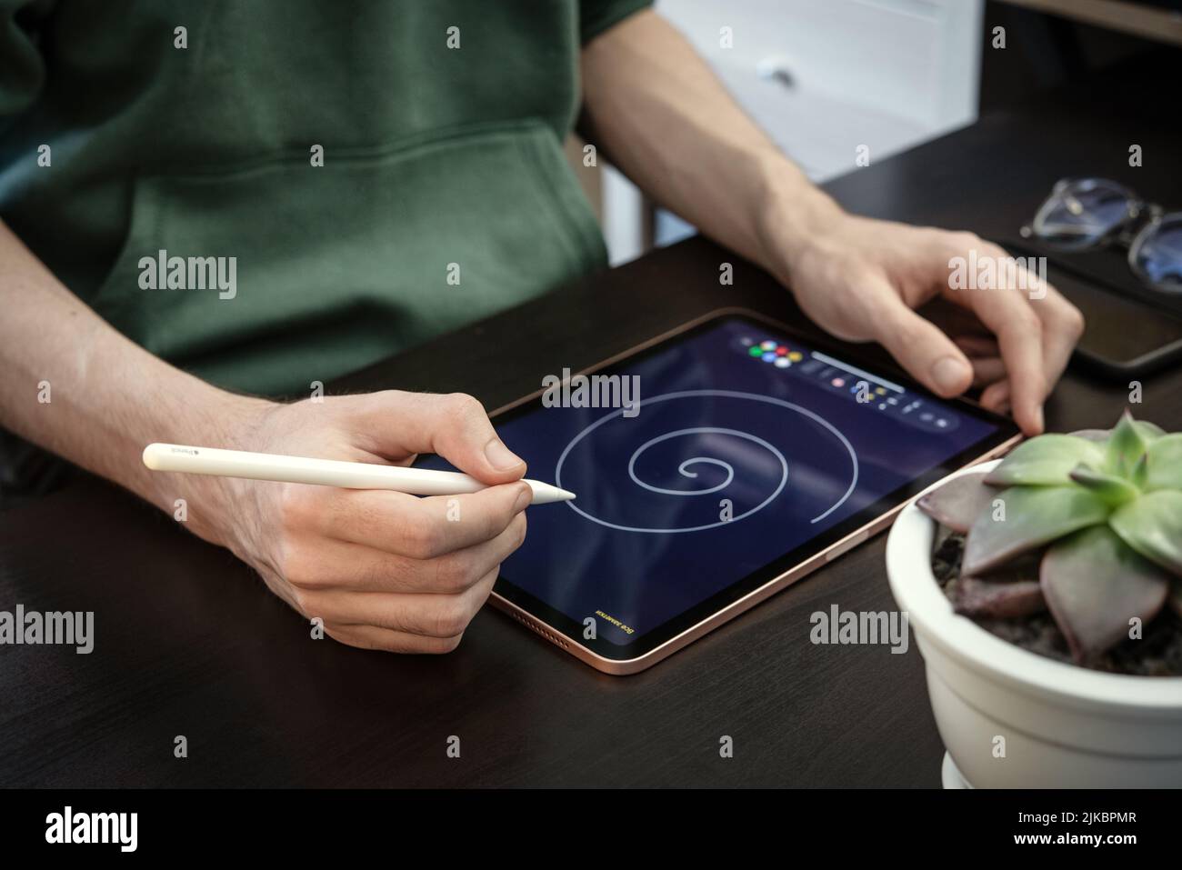 KIEV, UKRAINE - DECEMBER 21, 2021:Man with Apple Pencil using iPad Pro ...