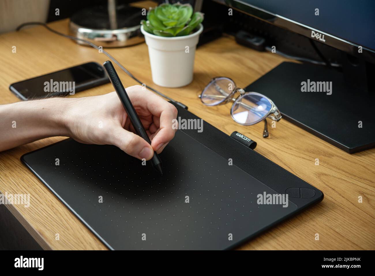 KIEV, UKRAINE - DECEMBER 21, 2021: Young graphic designer man using ...