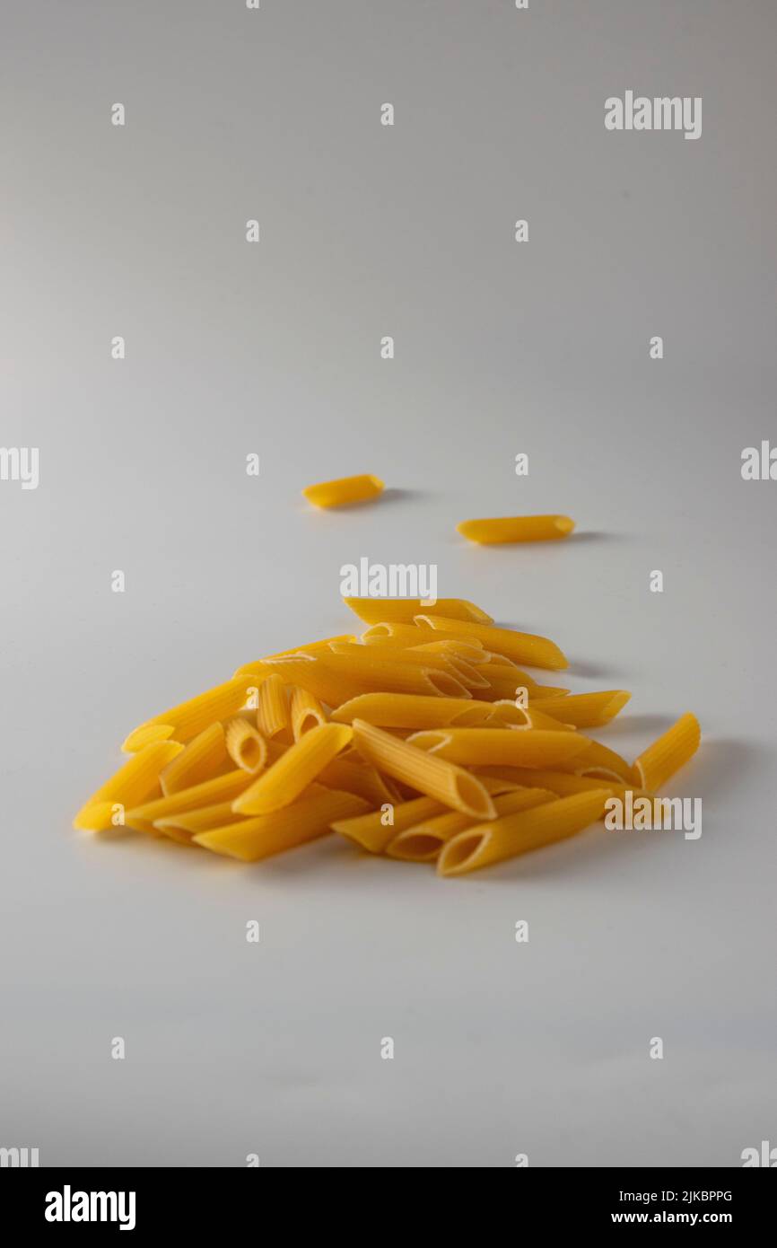 Penne rigate italian pasta scattered freely on a white background Stock ...