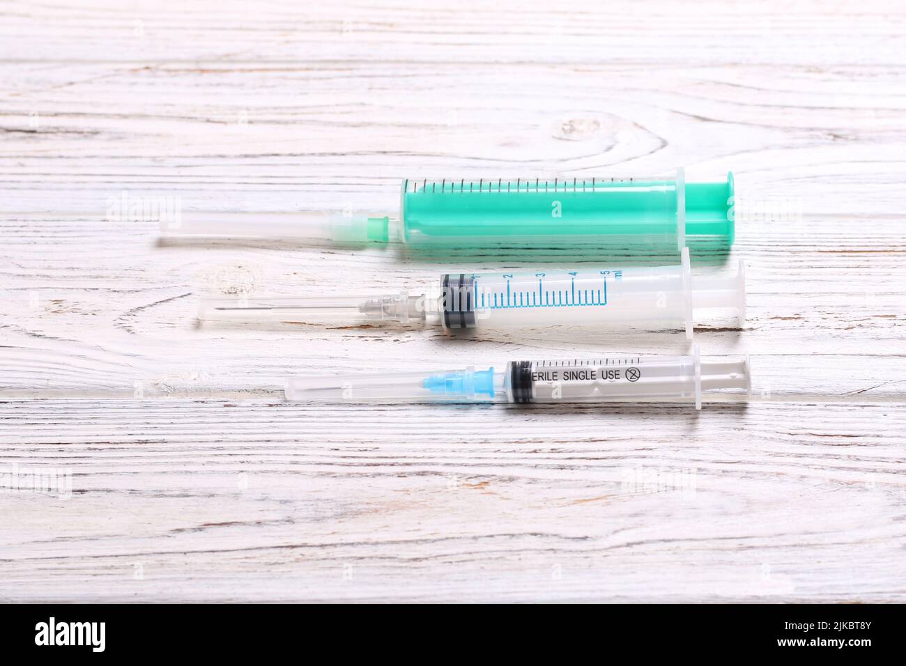 Top view of syringes of different sizes on wooden background. Medical ...