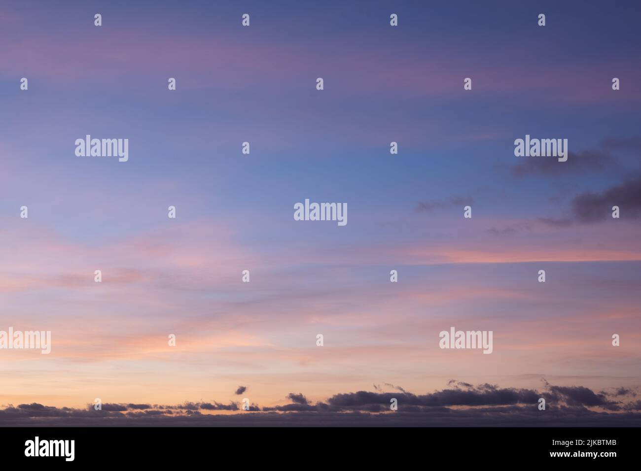Bright colored sky during dusk hour with golden clouds reflecting the ...