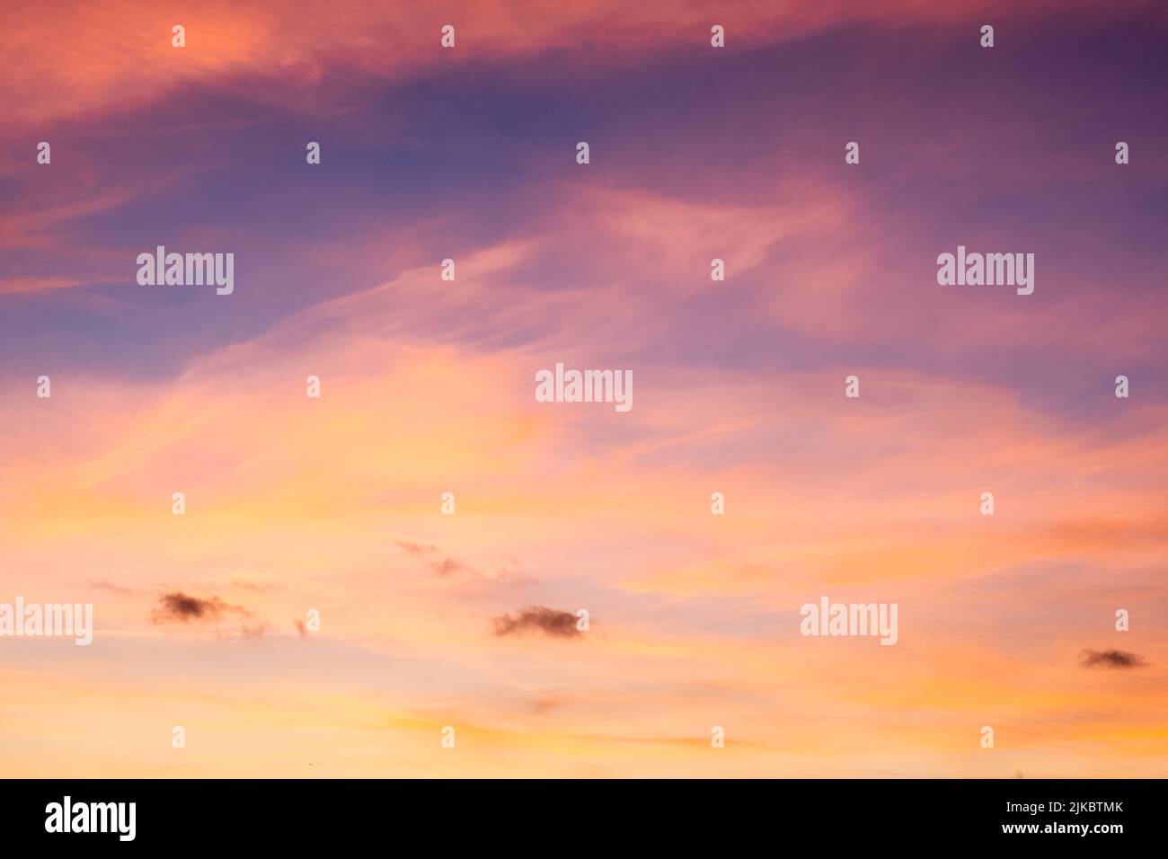 Bright colored sky during dusk hour with golden clouds reflecting the ...