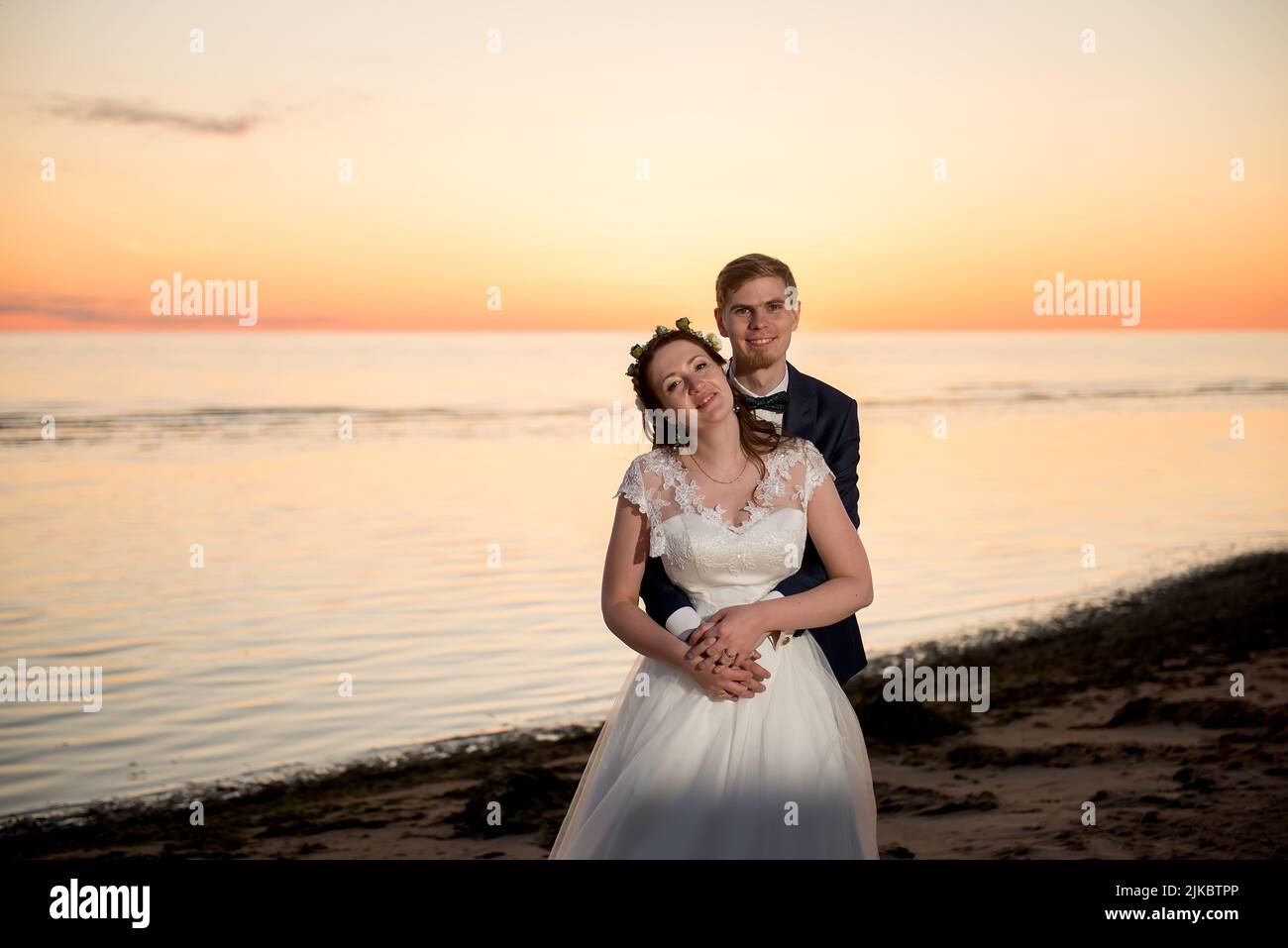 A happily married Caucasian couple standing on the beach on their ...