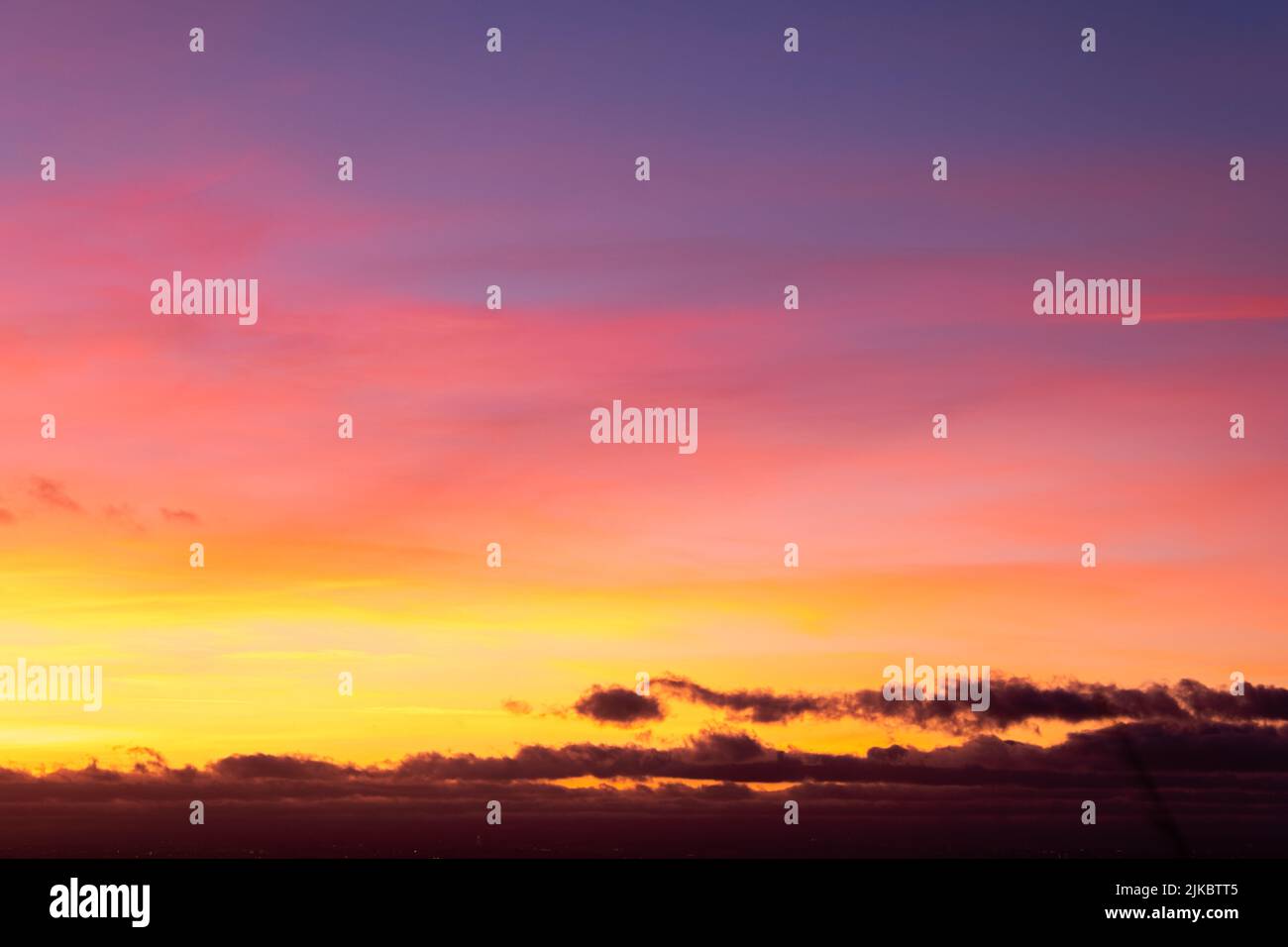 Bright colored sky during dusk hour with golden clouds reflecting the ...