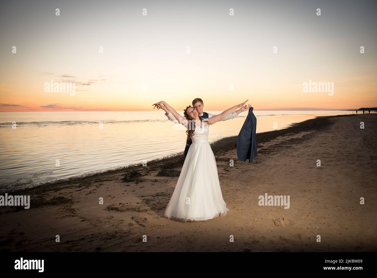 A happily married Caucasian couple standing on the beach on their ...
