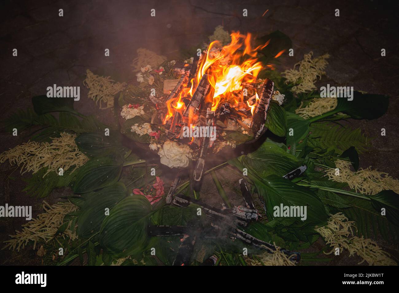 A camp bonfire with flowers during Latvian wedding ritual Stock Photo ...