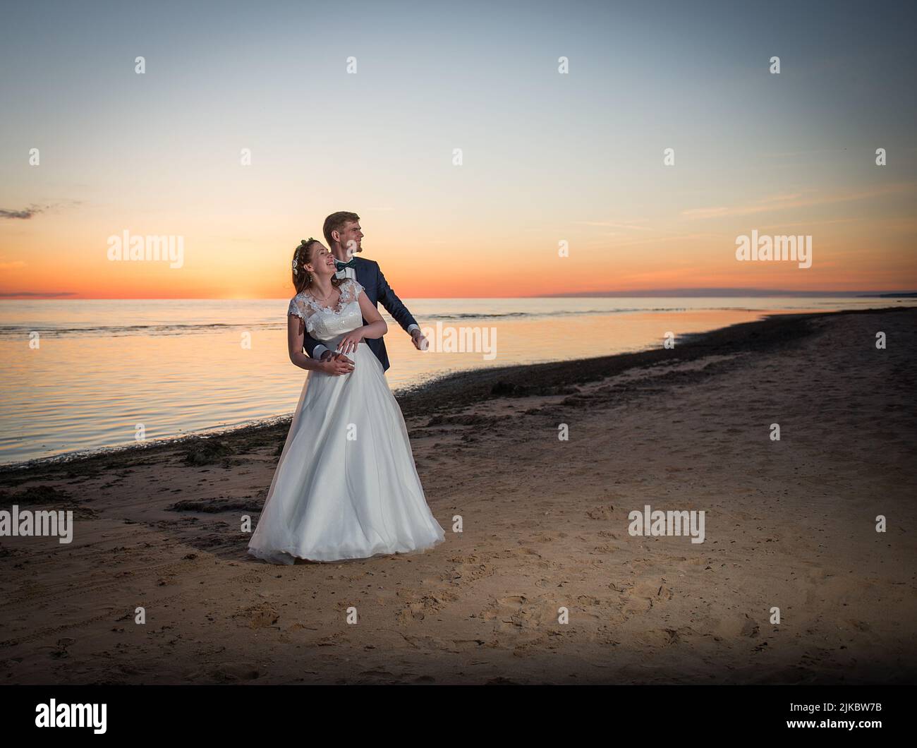 A happily married Caucasian couple standing on the beach on their ...