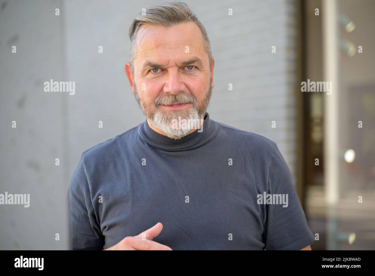 Bearded senior man staring intently at the camera with a serious ...