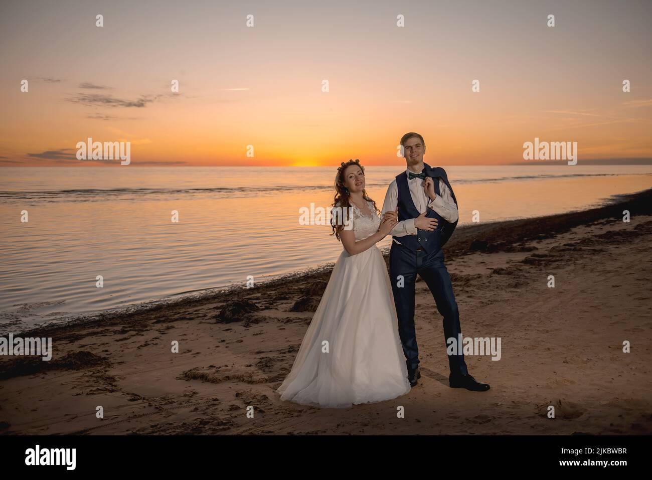 A happily married Caucasian couple standing on the beach on their ...
