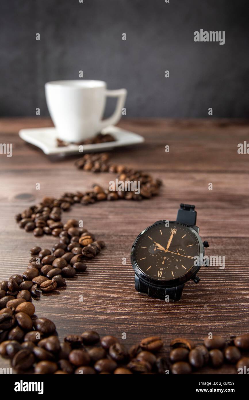 Watch showing best time for coffee with cup of coffee in the background ...