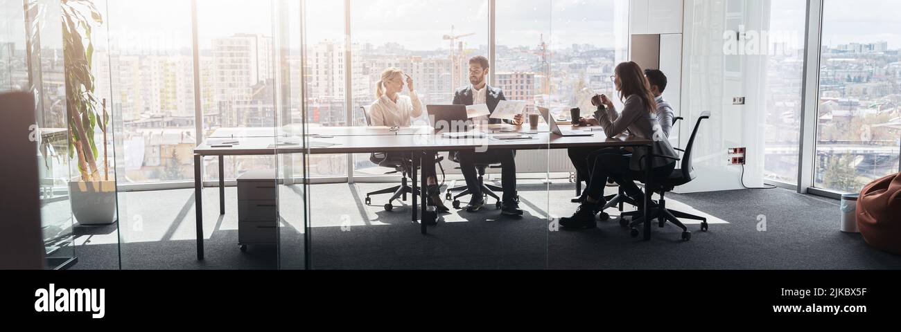Team of businessmen communicating together in modern office with ...