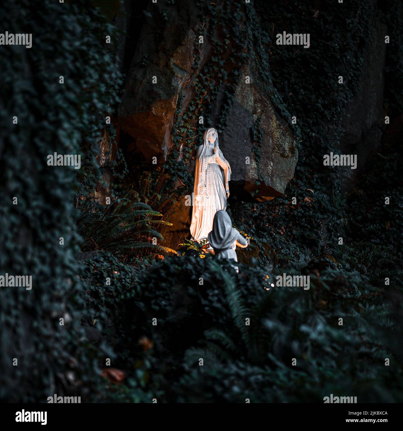A lighted statue of virgin Mariam in a cave Stock Photo - Alamy