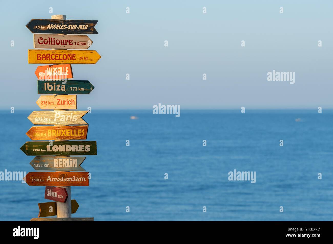 A closeup of wooden direction signposts with different European cities ...