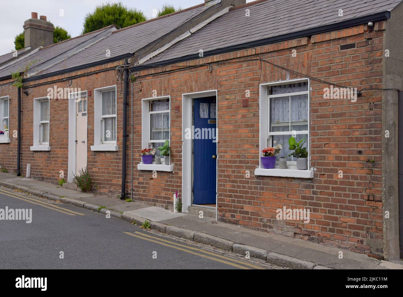 A row of traditional Irish brick terraced cottages in Dalkey, Leinster ...