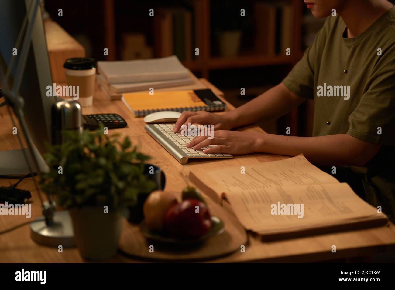 Hands of adult female student typing on computer keyboard while ...
