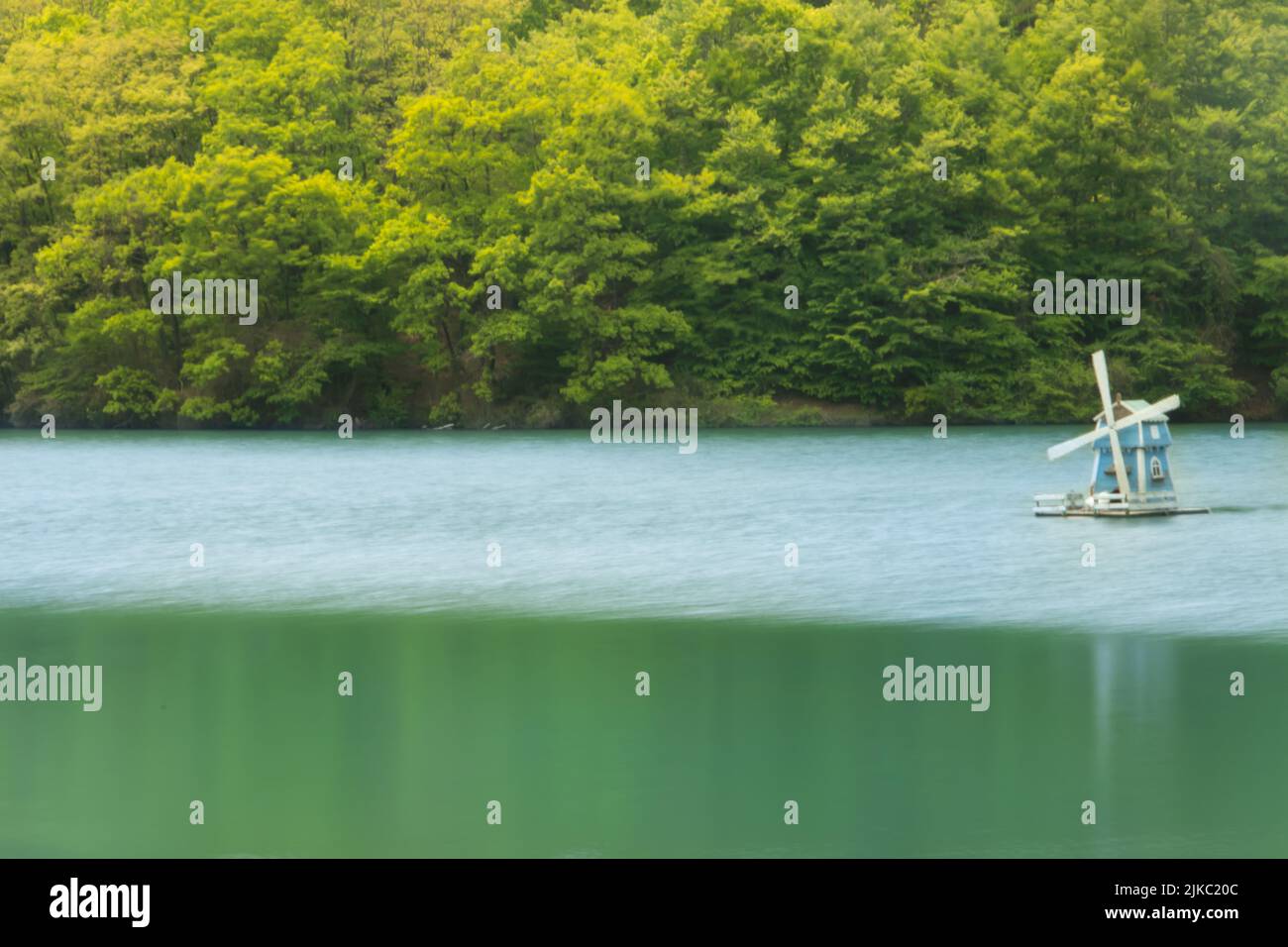 A floating mill house on the river surrounded by dense trees Stock ...