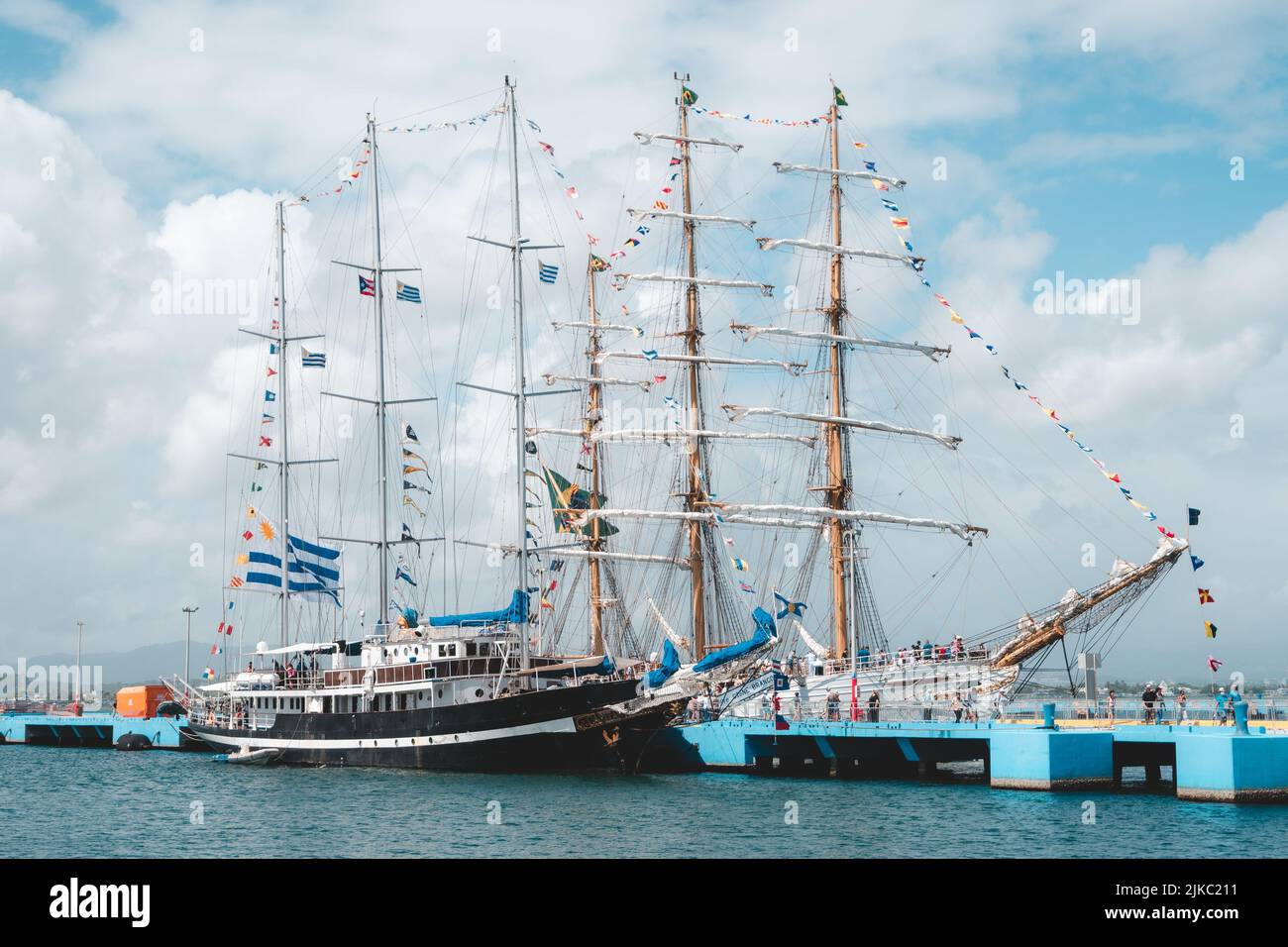 A regatta sailboat decorated with international flags in the port of ...