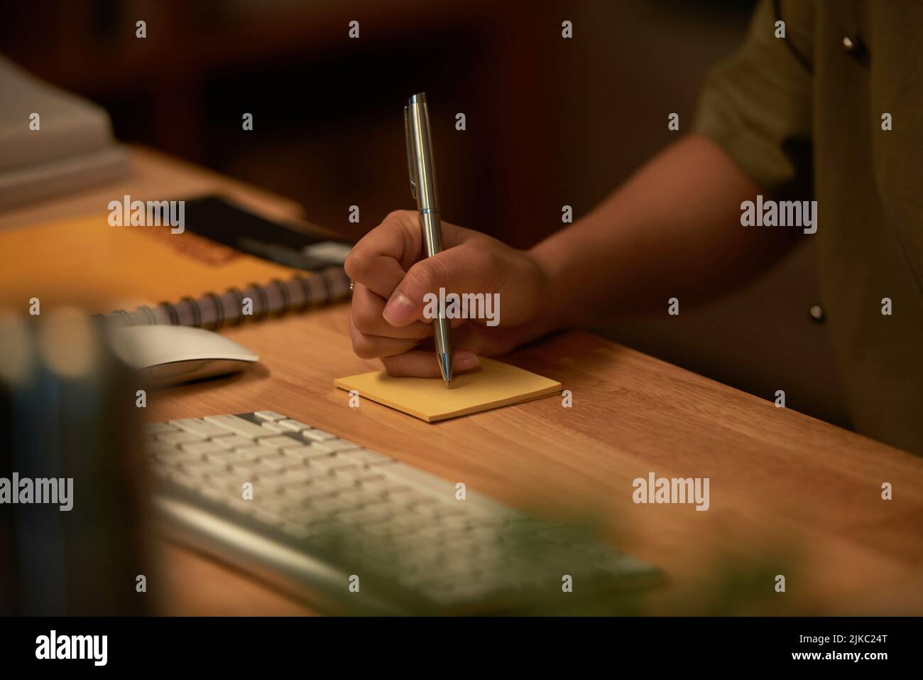 Close-up of hand making a note with pen on sticky paper Stock Photo - Alamy