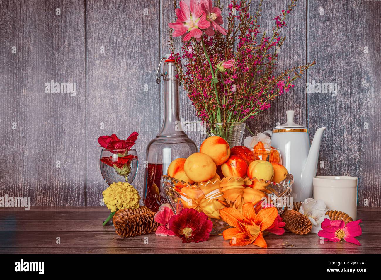 Positive summer still life with bottle of wine bouquet of flowers and ripe peaches in vases wine ...