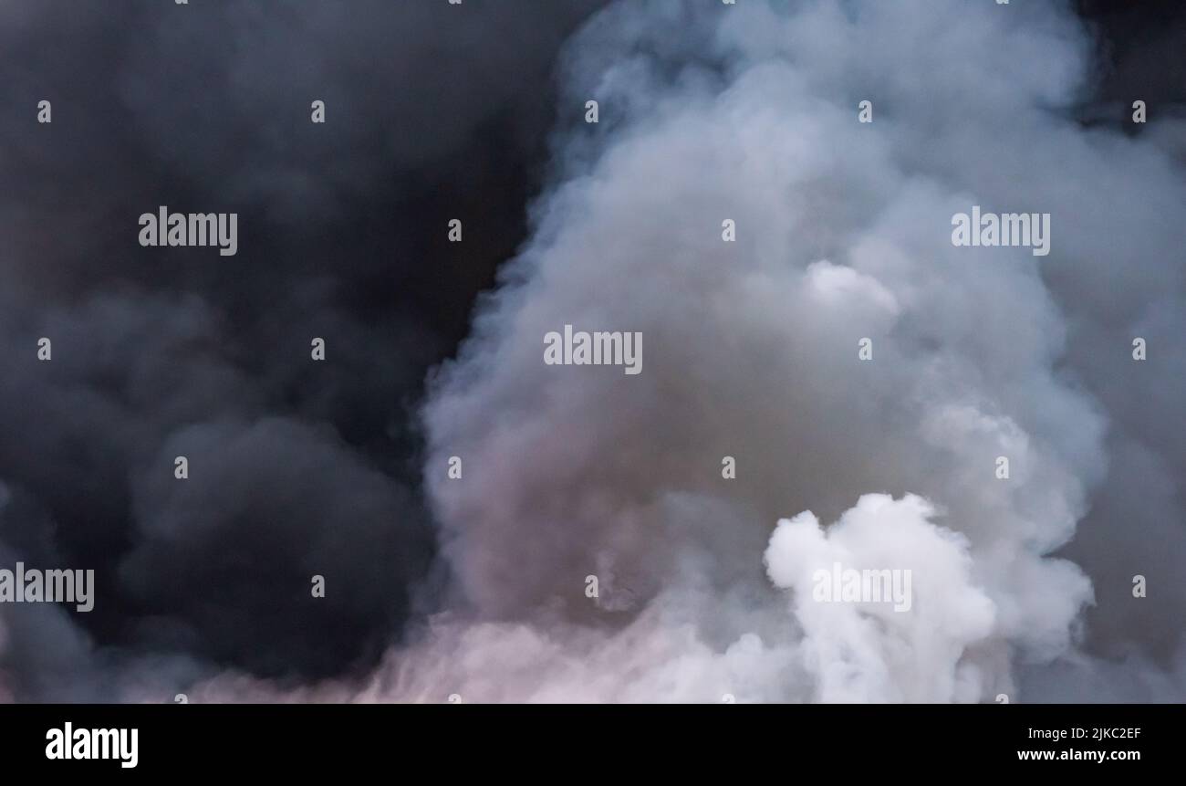 A cloud of black smoke from a fire in a building materials warehouse ...