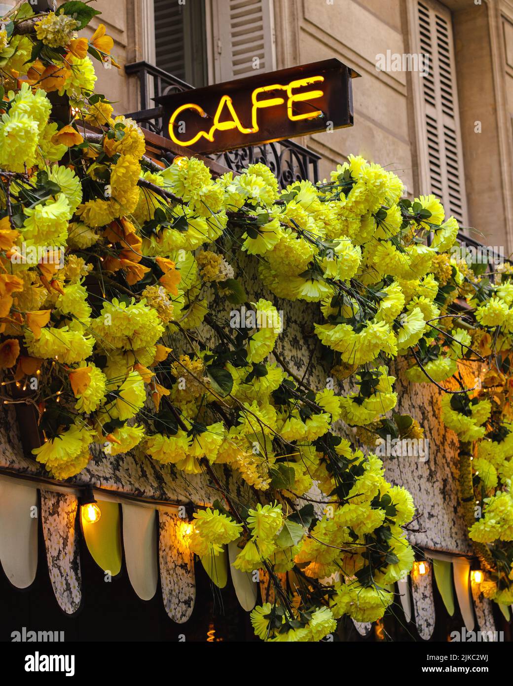 a vertical shot of a cafe entry with nice yellow flowers and a "cafe ...