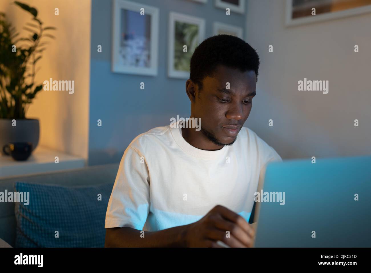 African American programmer writes code for website looking at screen ...