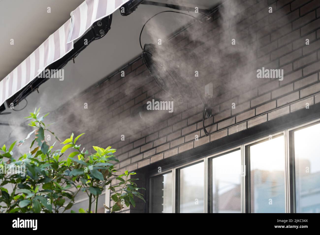 Water spray system and fans working for cooling air in street cafe on ...