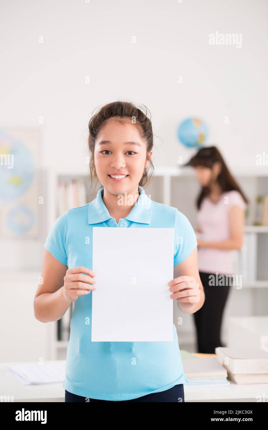 Portrait shot of pretty Asian pupil posing for photography with toothy ...
