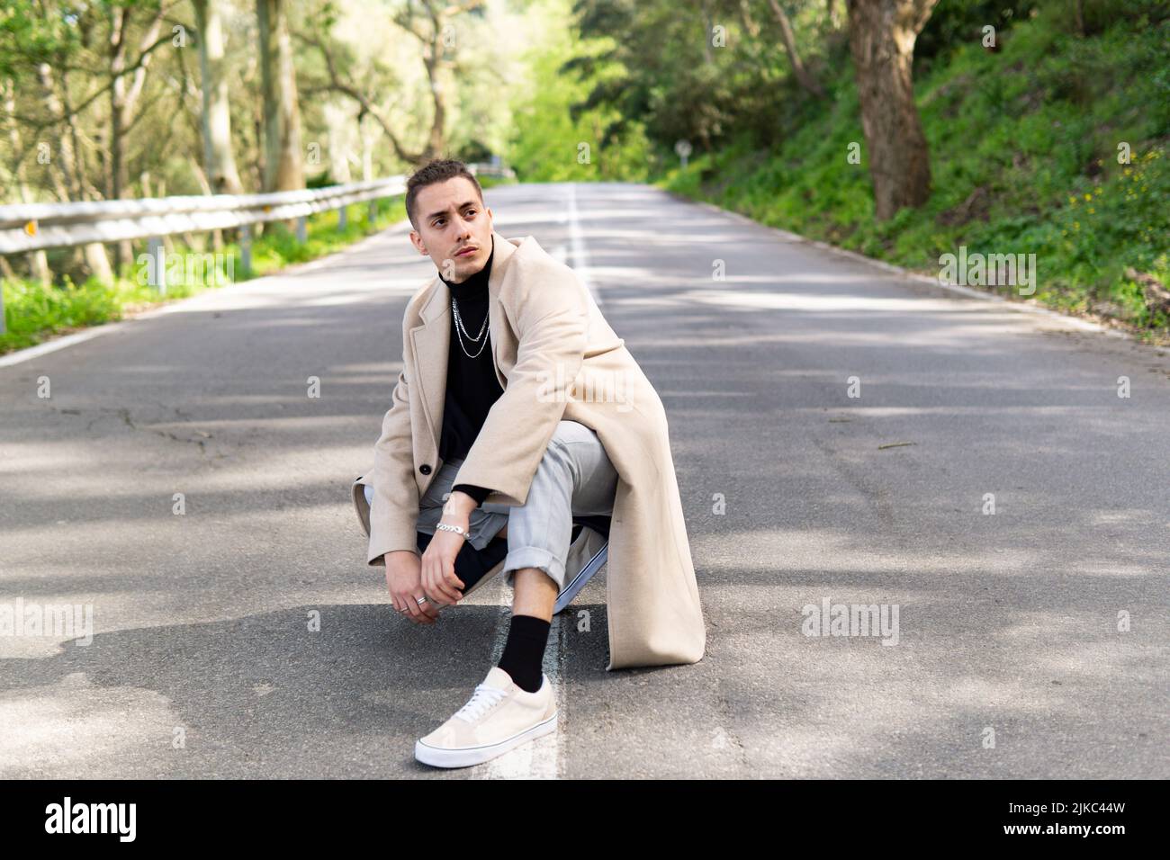 Young Hispanic Arab man posing on the road, gazing into infinity, copy ...