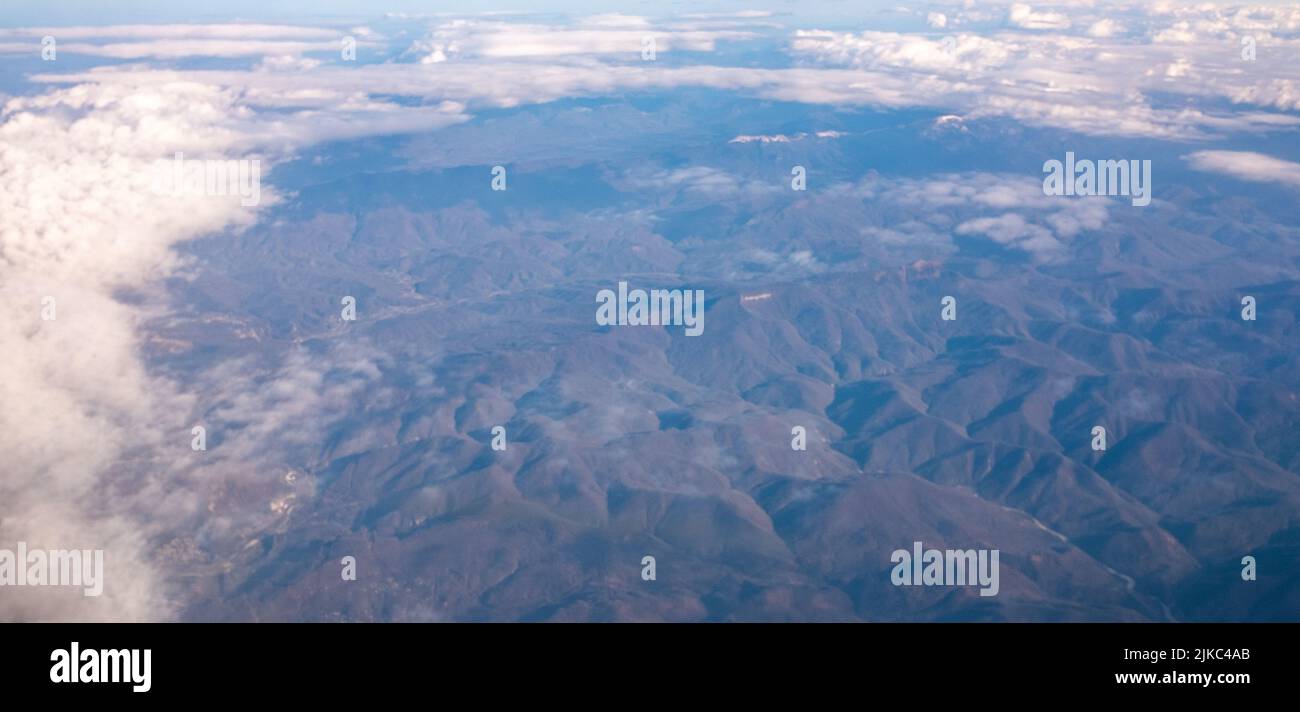 a bird's-eye view of the mountains and clouds in the sky from an ...