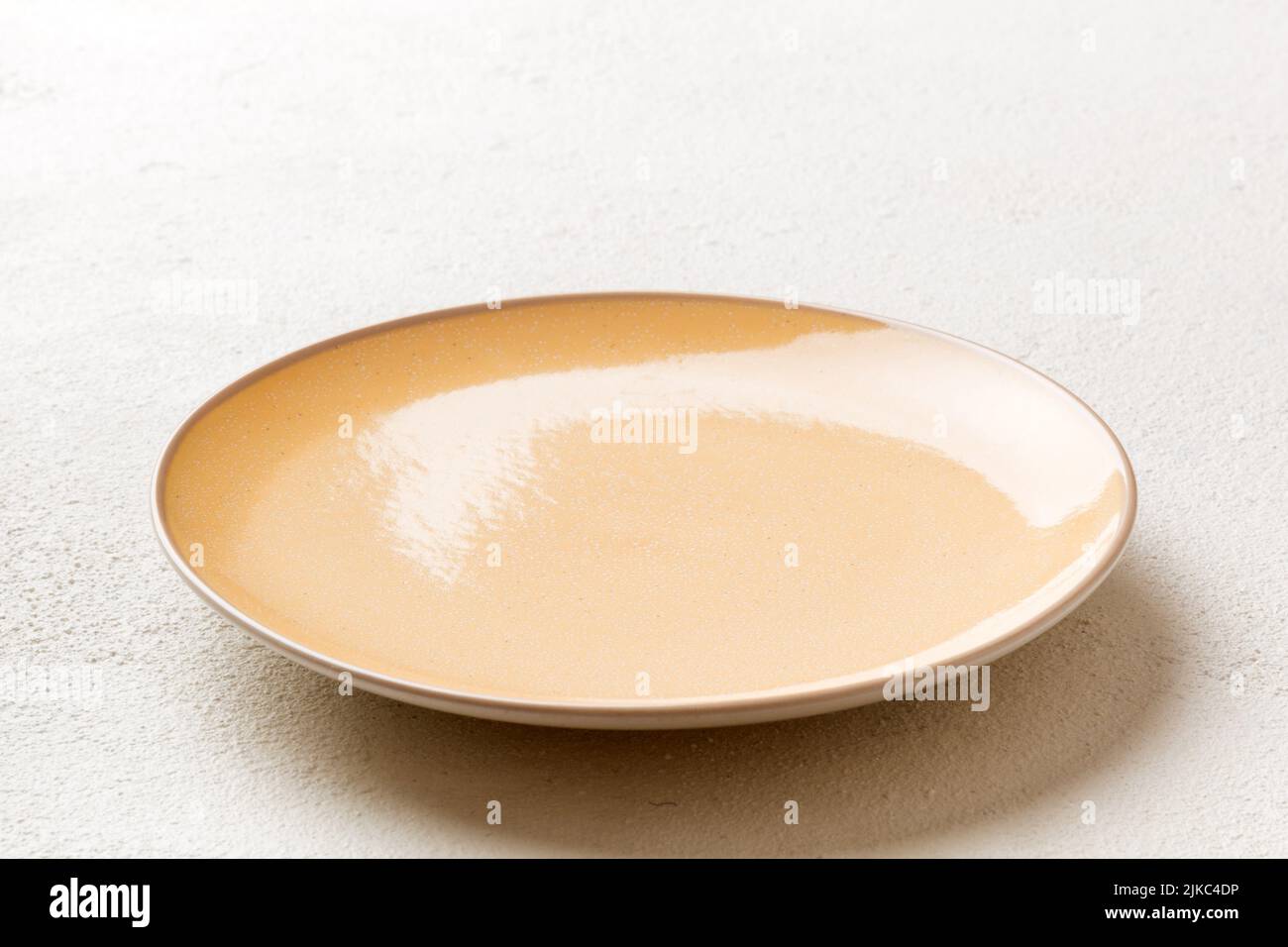 Perspective view of empty orange plate on cement background. Empty ...