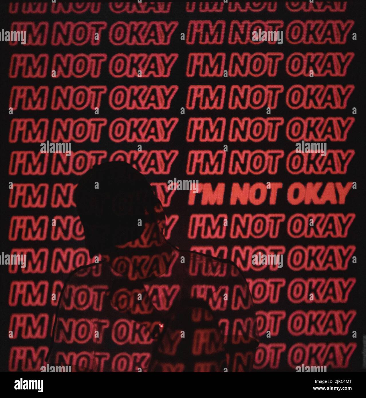 A projector photography with red 'I'm not okay' text and human shadow ...