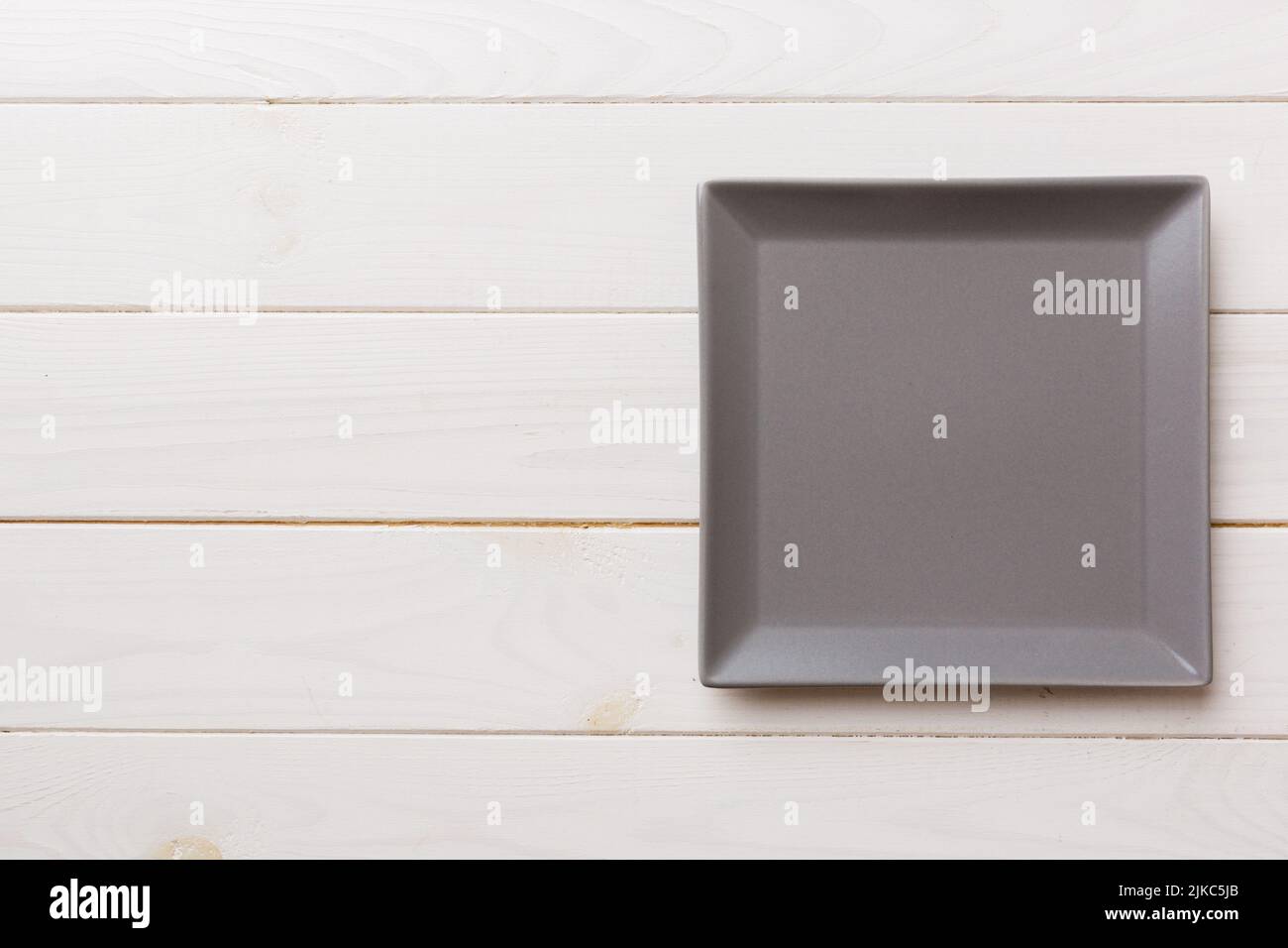Top view of empty square plate on wooden background. Empty space for ...