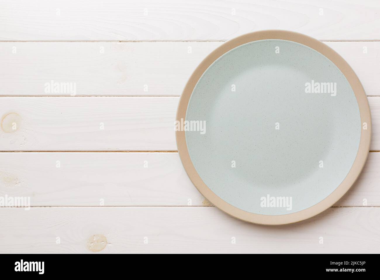 Top view of empty light plate on wooden background. Empty space for ...