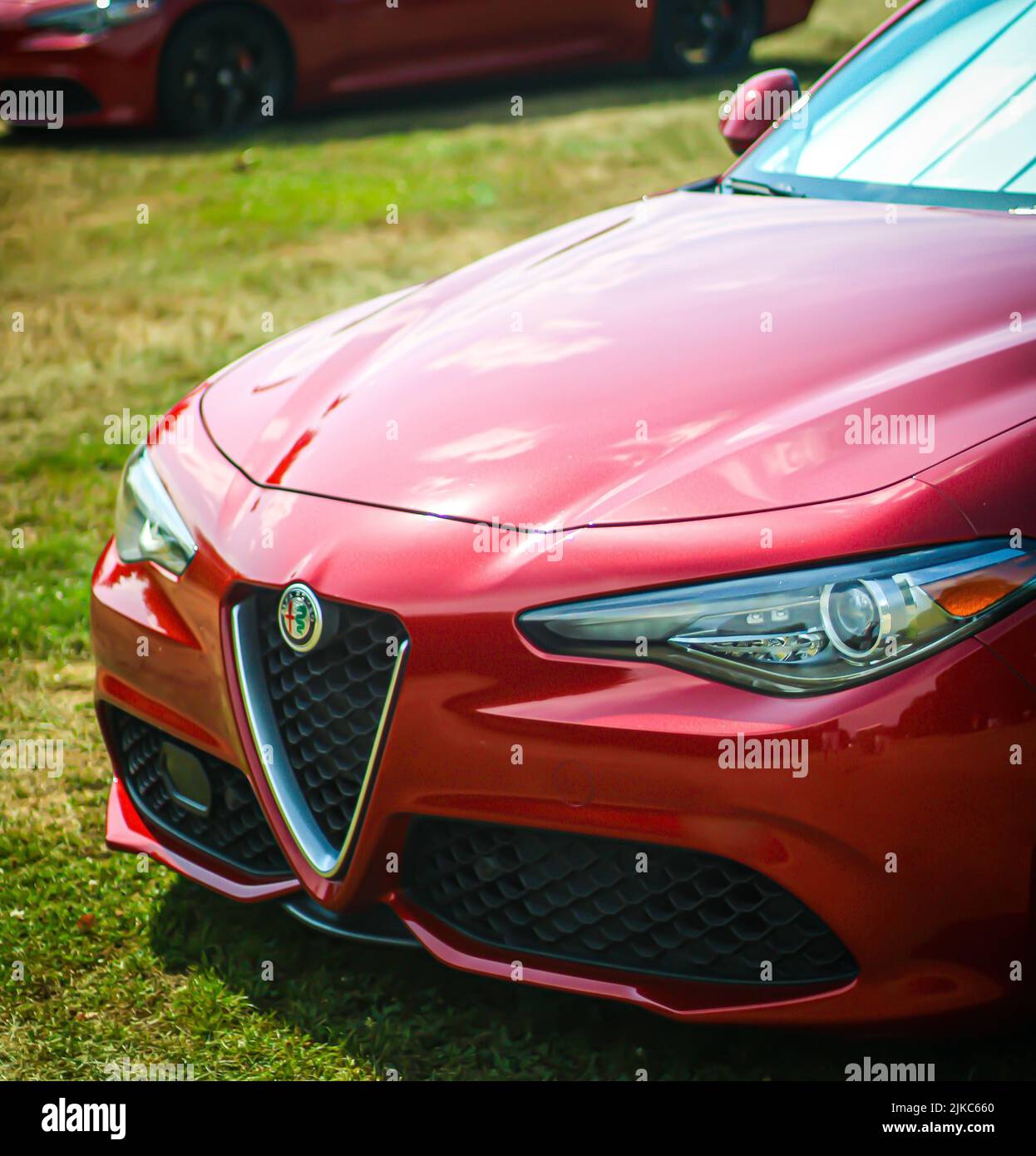 A red Alfa Romeo Giulia parked on green grass Stock Photo - Alamy