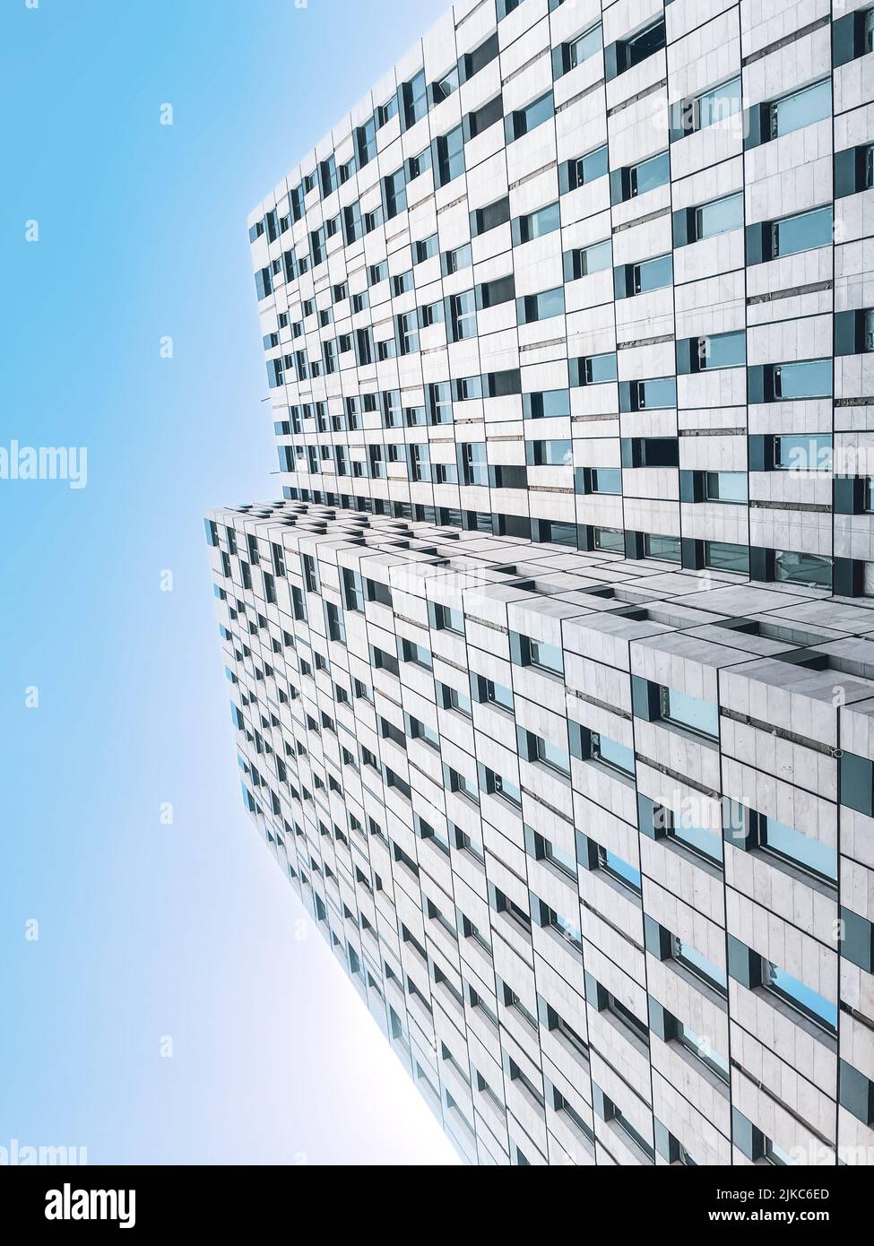 A low angle of a high-rise glass building with beautiful clear sky in ...