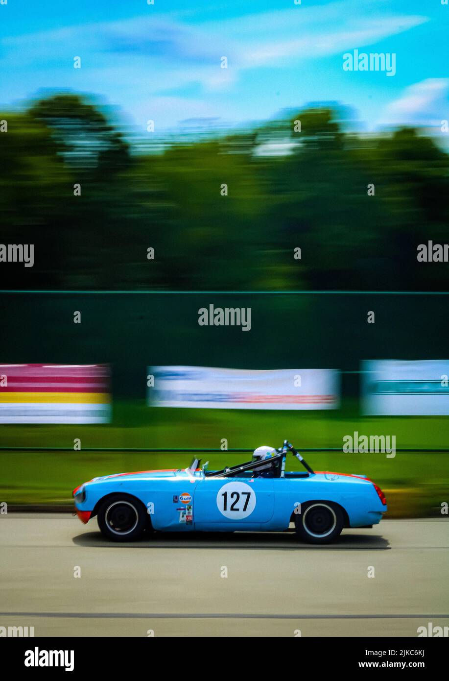A classic blue car driving fast on a racing track at the Pittsburgh ...