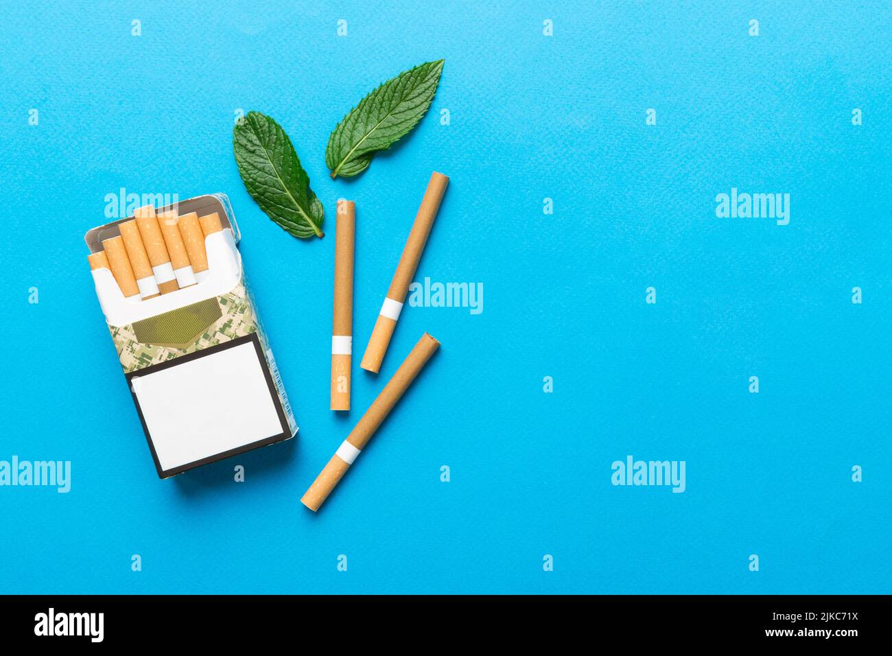 Pack of menthol cigarettes and fresh mint on colored table, Menthol ...