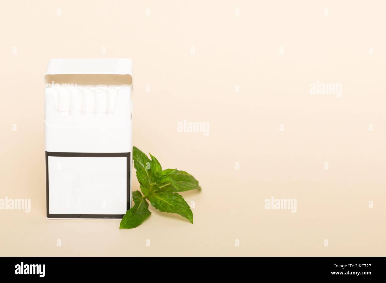 Pack of menthol cigarettes and fresh mint on colored table, Menthol ...