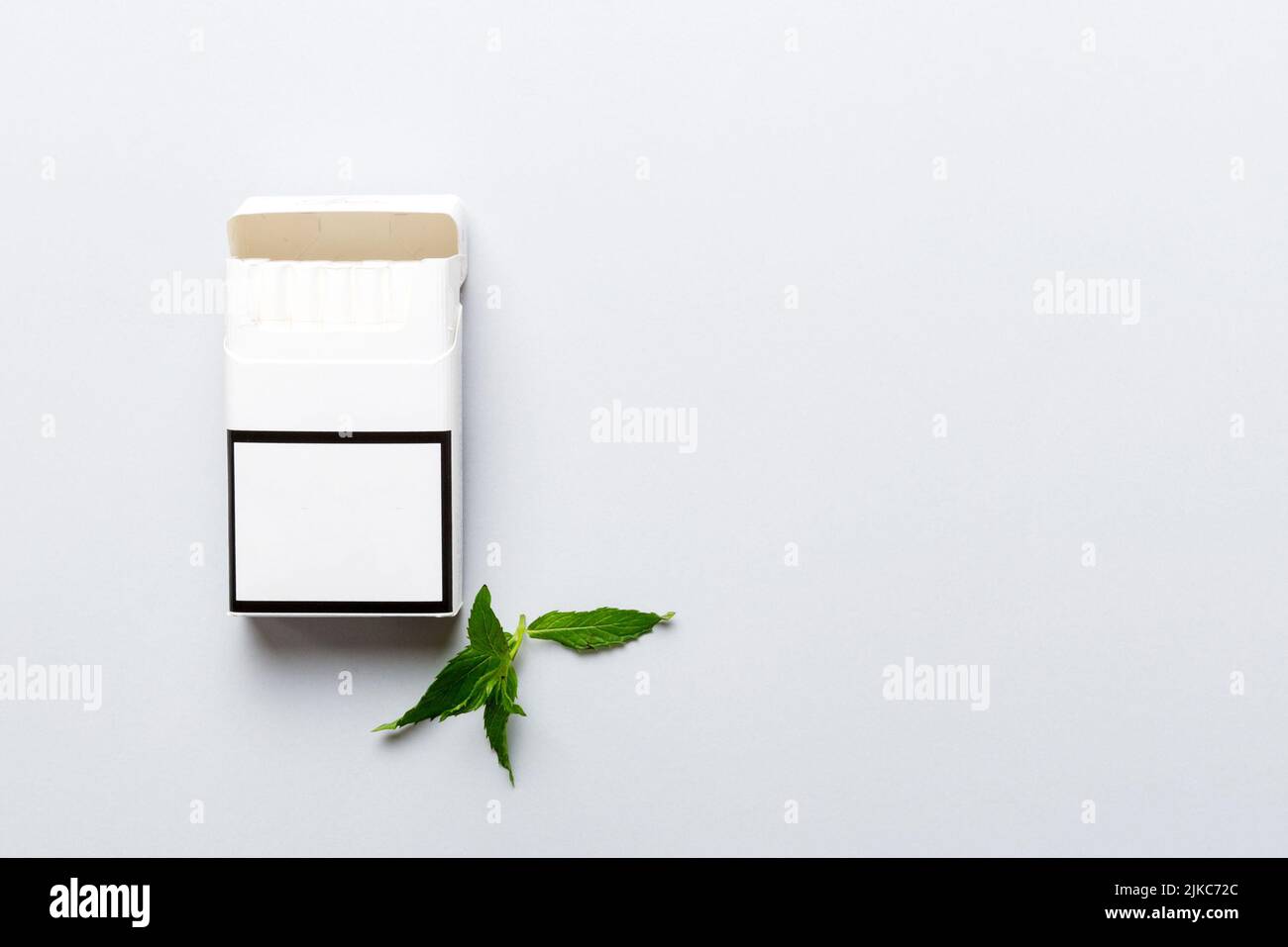 Pack of menthol cigarettes and fresh mint on colored table, Menthol ...