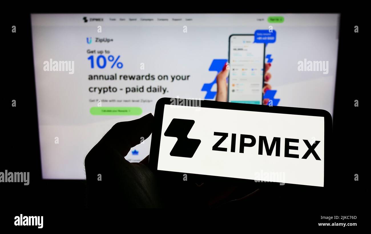 Person holding mobile phone with logo of Singaporean crypto company ...