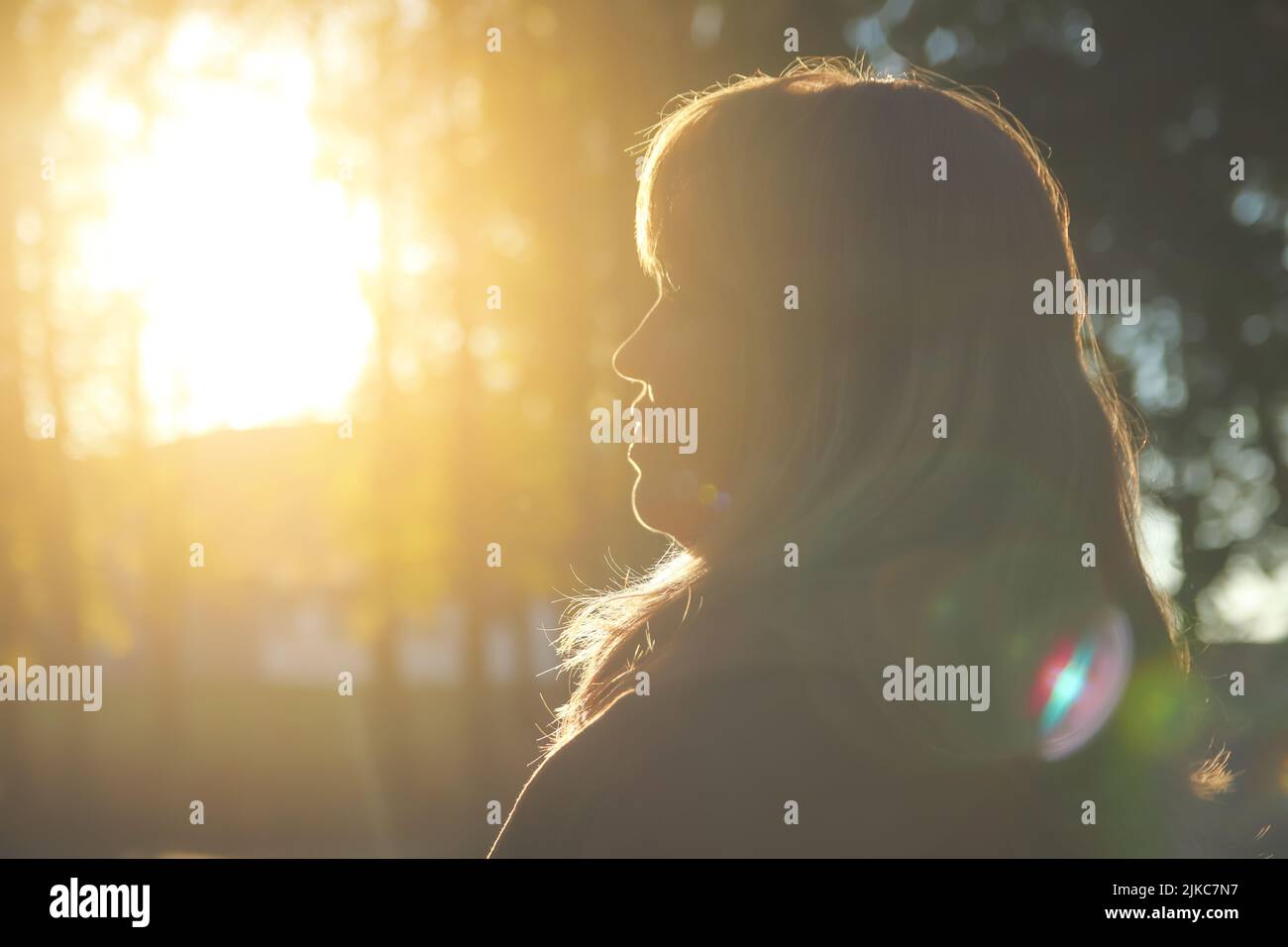 Defocus close-up silhouette of woman looking at sunrise. Mental health ...