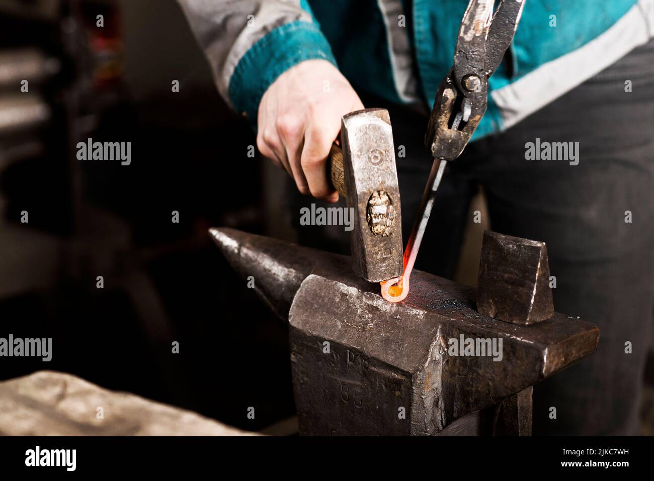 A closeup shot of a blacksmith hammering a hinge on an anvil Stock ...