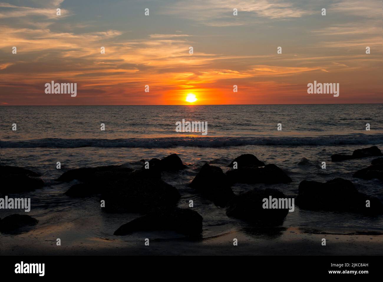 A beautiful golden sunset on a rocky beach - perfect for background ...