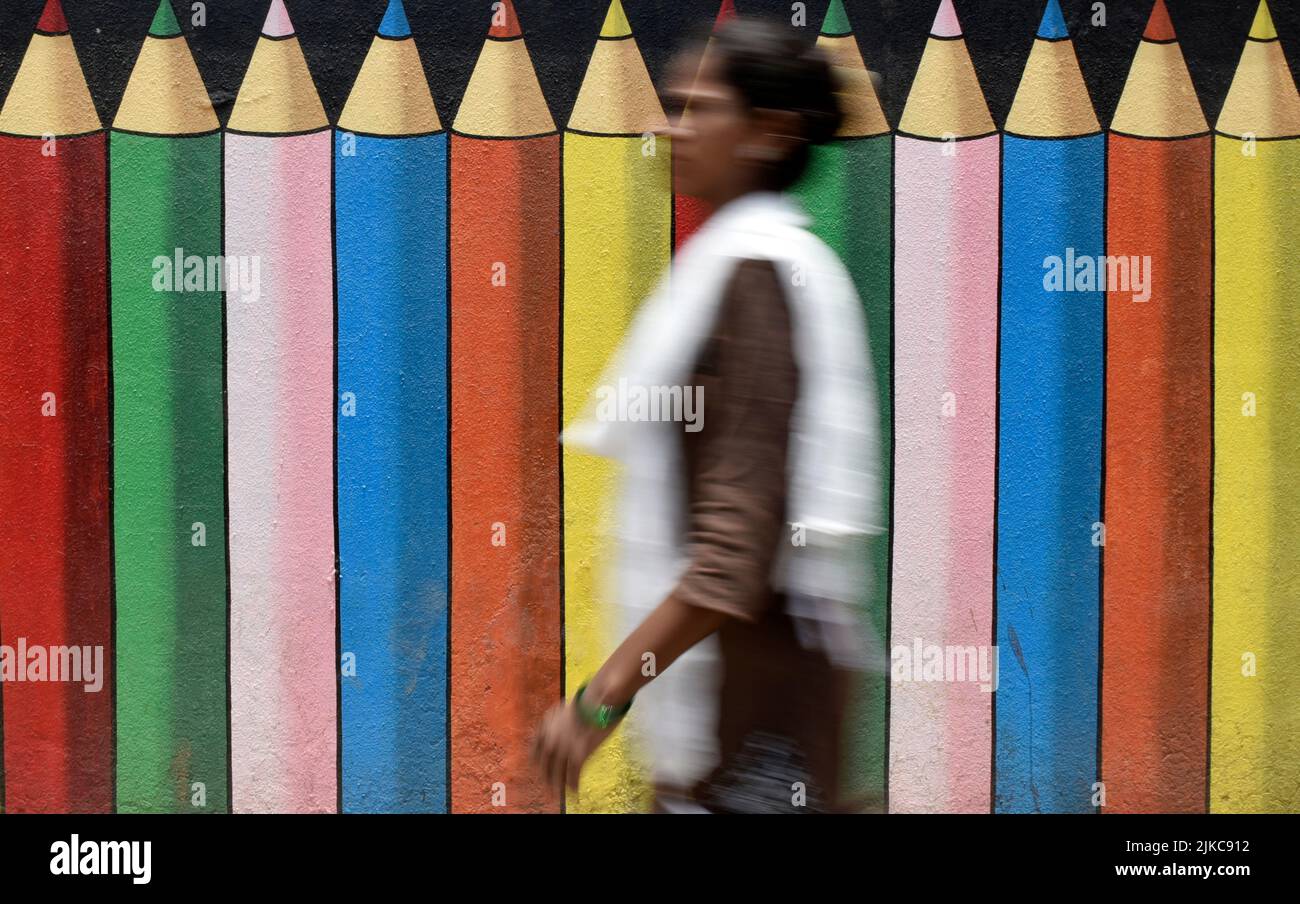 Mumbai, Maharashtra, India. 1st Aug, 2022. A woman walks past a wall ...