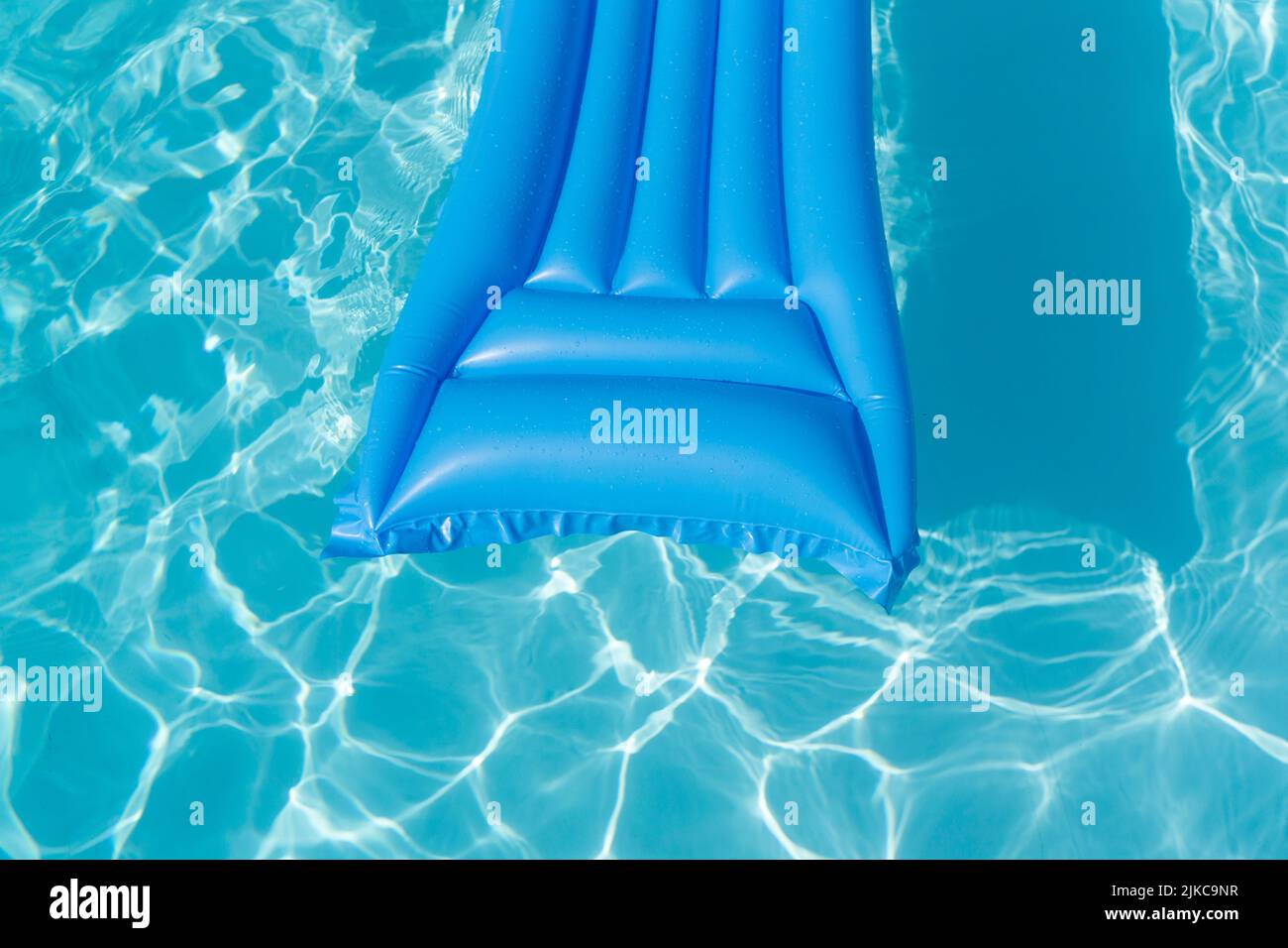 Bright blue summer pool lounger float on a rippled swimming pool Stock ...