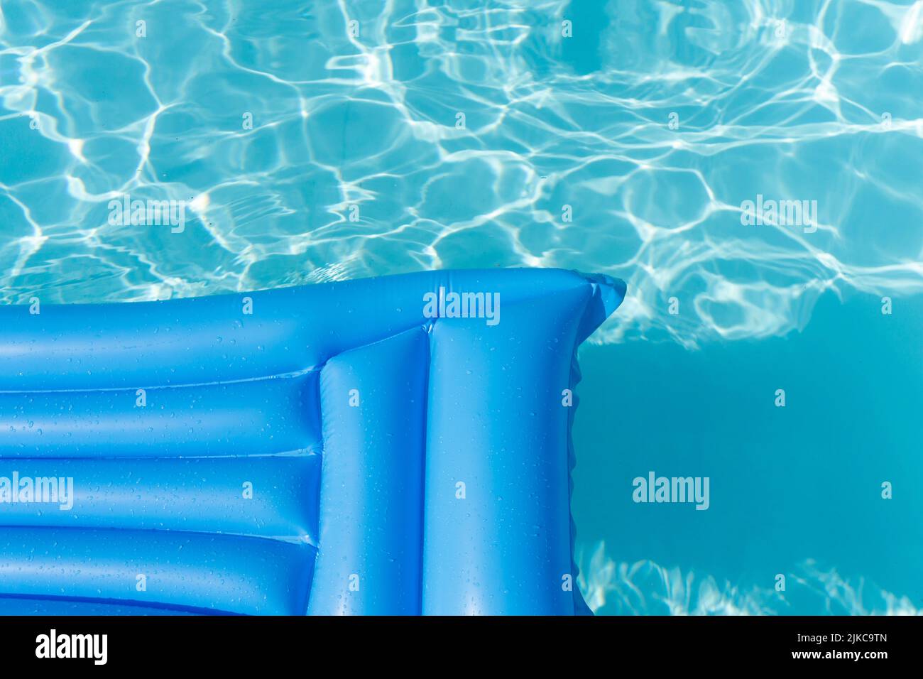 Bright blue summer pool lounger float on a rippled swimming pool Stock ...
